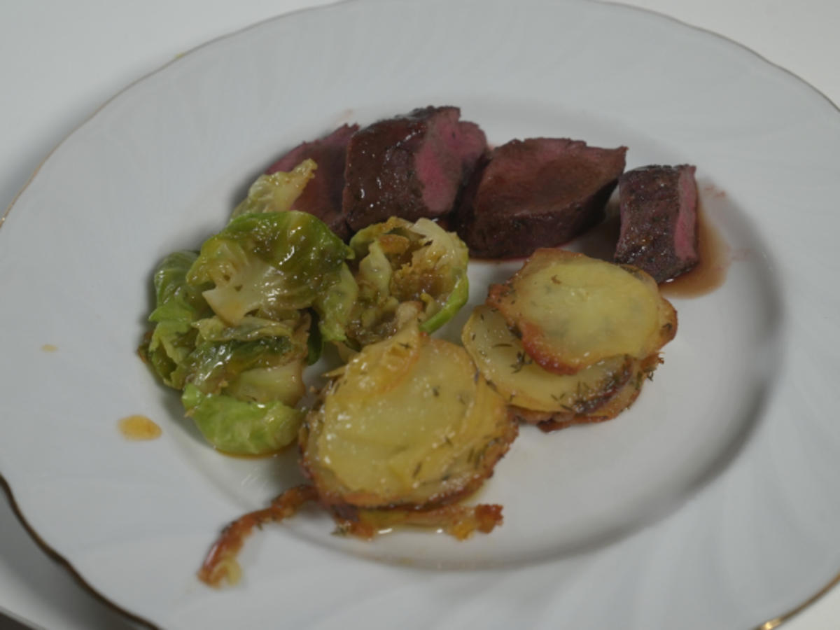Rehrücken mit Kartoffelstapel und Rosenkohlblättern, dazu dunkle Soße ...